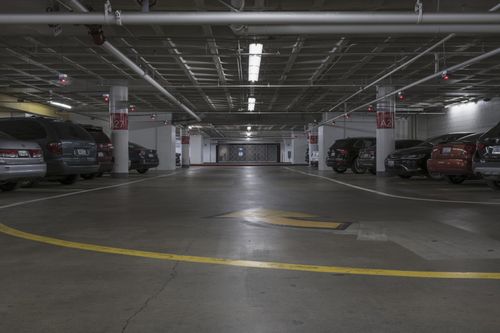 Parking Garage with Multiple Cars Under Ceiling Lights