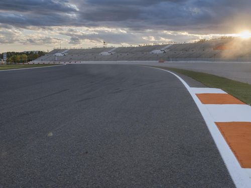 Sunlit Race Track on Valencia Straight Road with Dramatic Mountains