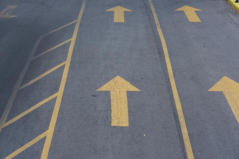 Arrow Symbols Painted on Roadway with Light Pole and Yellow Curbing ...