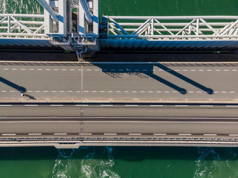 Overhead View of a Modern Bridge over Water with a Boat Passing Through ...