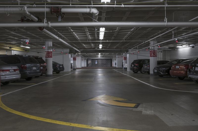 Parking Garage with Multiple Cars Under Ceiling Lights