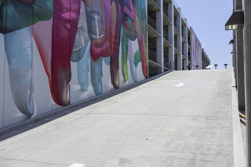 People walking near a large mural on a building in Los Angeles ...