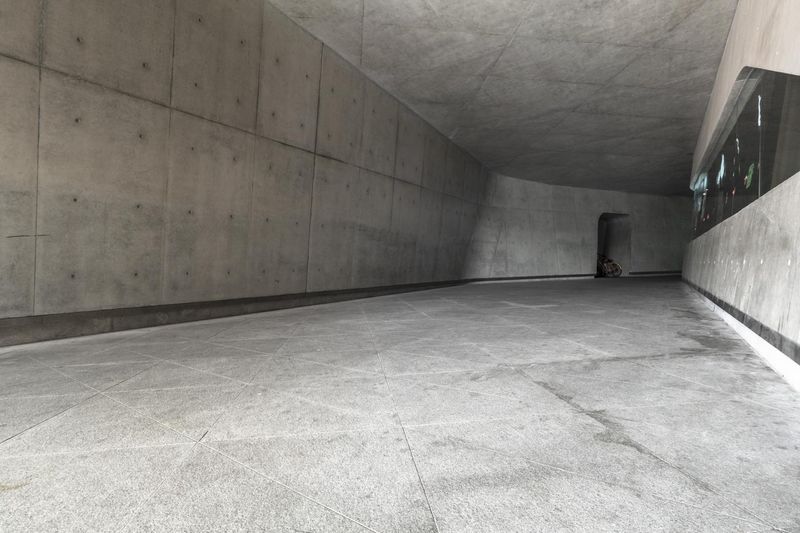 Skateboarder in Concrete Alleyway with Reflection Wall