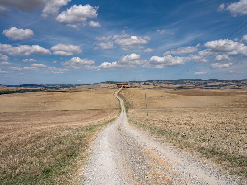 Exploring the Tuscan Countryside: A Dirt Road Amidst Rugged Landscape ...